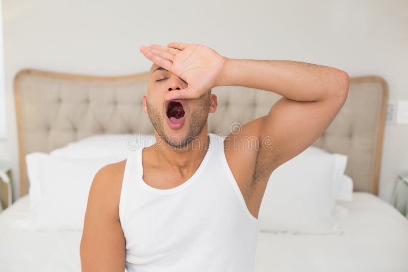 Young man yawning in bed stock photo. Image of expression - 35032288