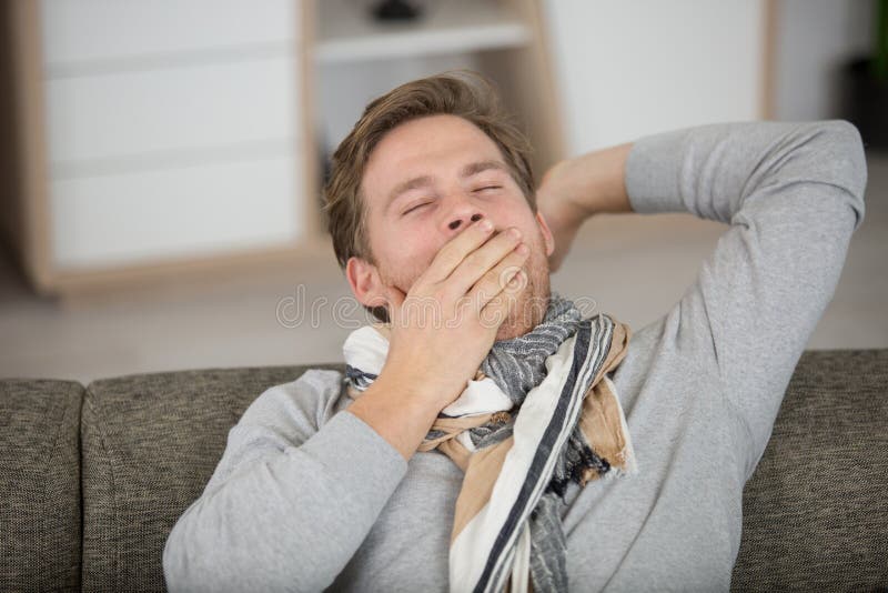 Young man yawning on sofa stock image. Image of teen - 244999635