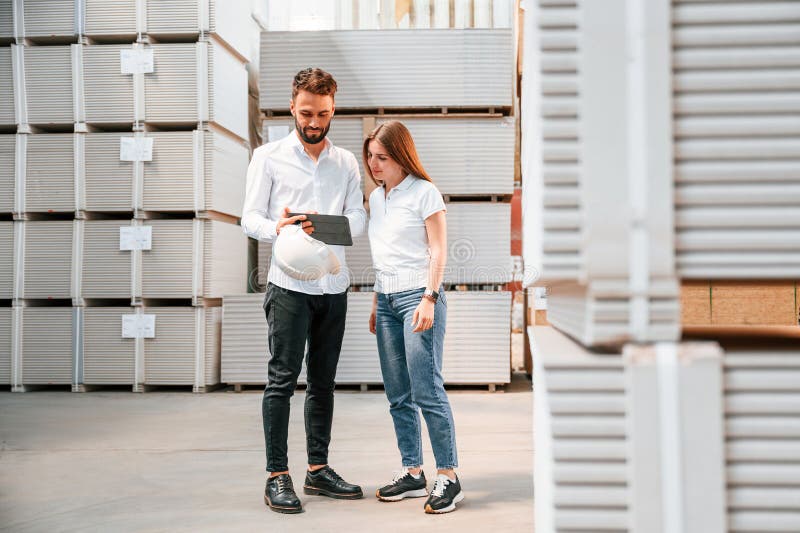 Young Manager in Formal Clothes is Working with Woman in the Warehouse ...