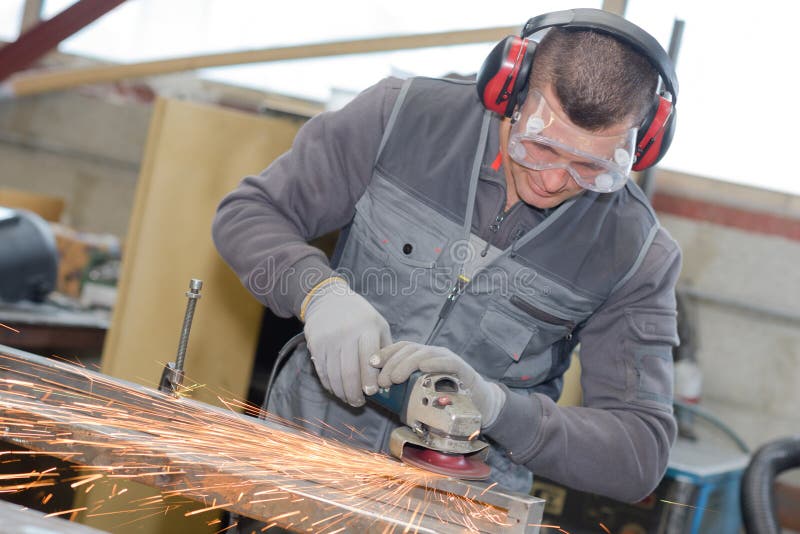Young Manual Worker Using Grinder on Metal in Factory Stock Image ...