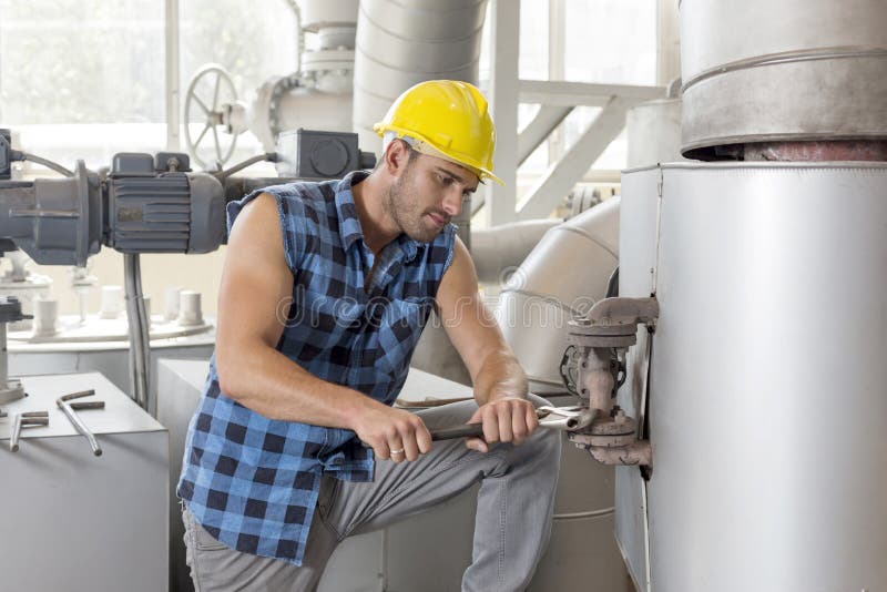 Young Manual Worker Using Wrench on Industrial Machine Stock Image ...