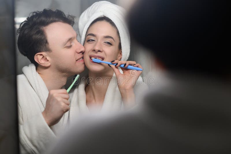 A Young Married Couple Brushing Their Teeth Together Dental Hygiene