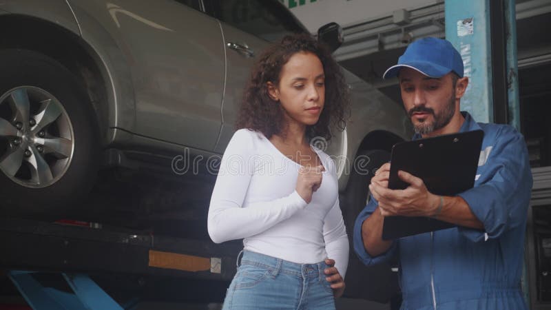 Young Man Mechanic Talking with Customer for Examining Trouble and ...