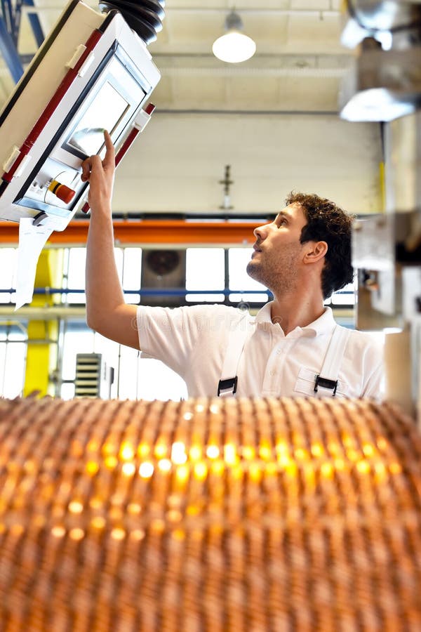 Young Mechanical Engineering Workers Operate a Machine for Winding ...