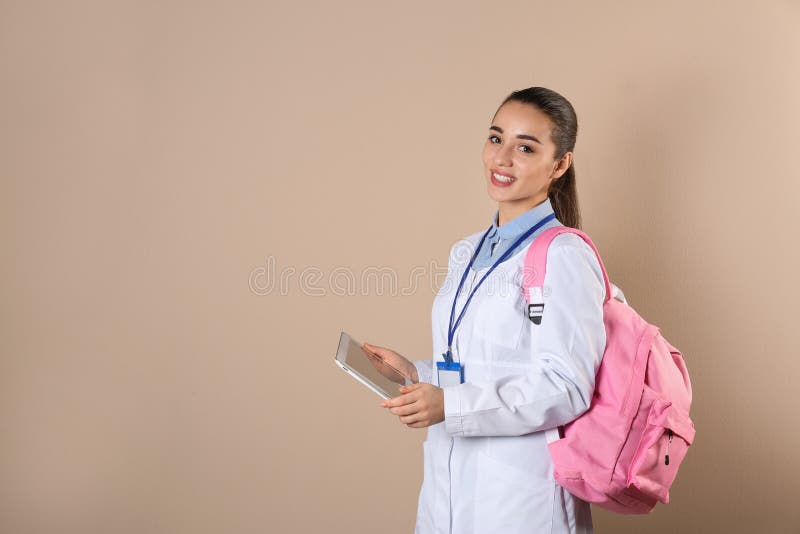 Young Medical Student with Tablet and Backpack on Color Background ...