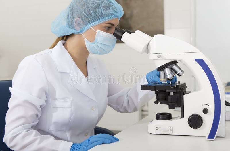 Young Medical Worker Looking on Samples through Microscope Stock Image ...