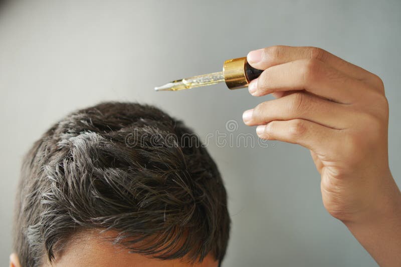 Young Men Applying Essential Oils on His Hair Stock Photo - Image of ...