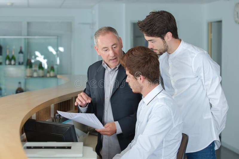 Young Men Being Trained at Reception Desk Stock Photo - Image of boss ...