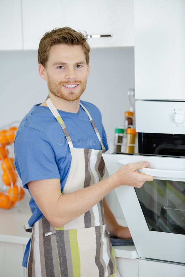 Young Man Controls Oven in Kitchen Stock Photo - Image of oven ...