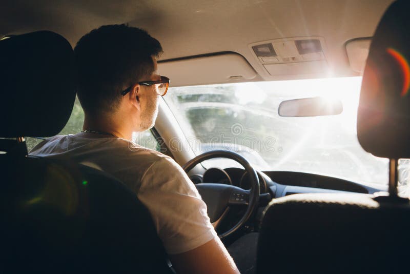 Young Man Driving a Car in the Setting Sun Stock Photo - Image of ...