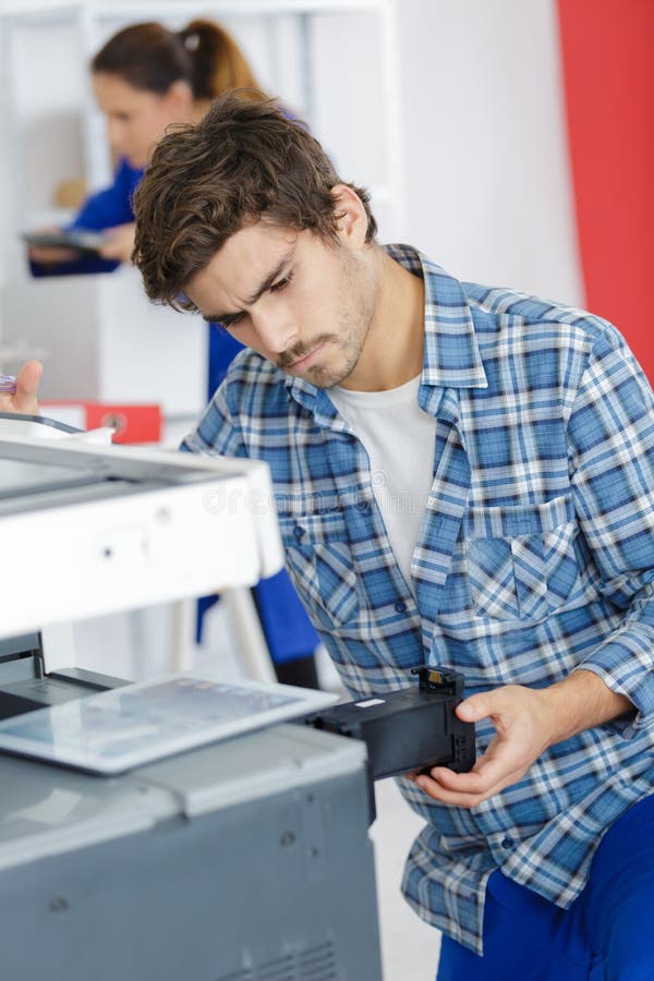 Young man fixing printer stock photo. Image of metallic - 124184608