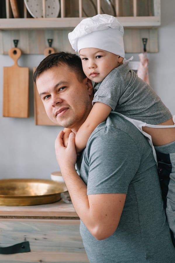 Young Man and His Son with Oven Sheet in Kitchen. Father with Little Son on the Kitchen Stock ...