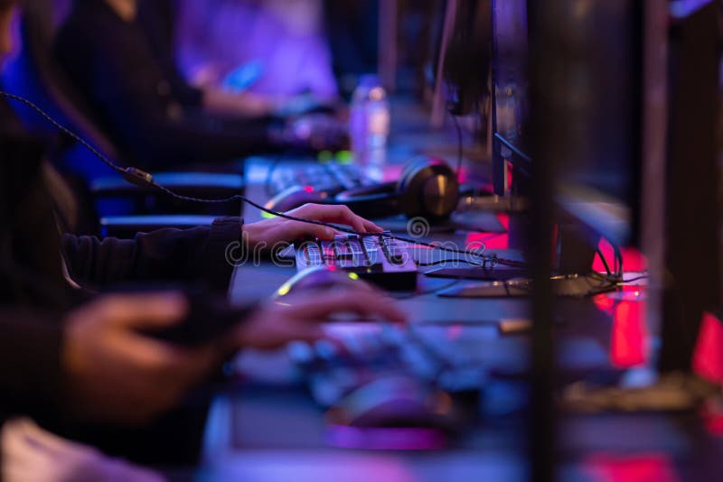 Young Men Sit at Computer Gaming Setups and Playing an Online Game ...