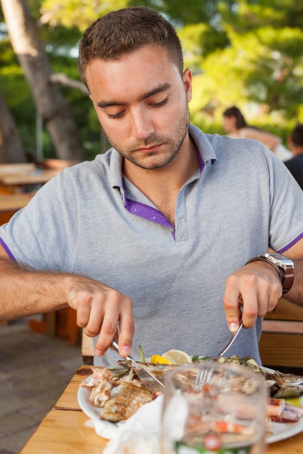 Young Men Sittin Behind Table Eating Seafod Stock Photos - Free ...