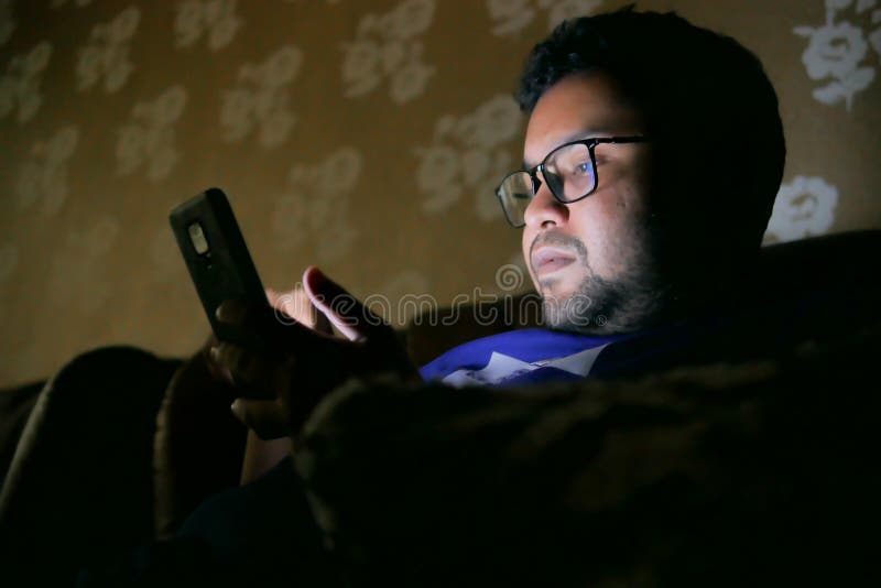 Young Men Sitting on Sofa Using Smart Phone at Night Stock Photo ...