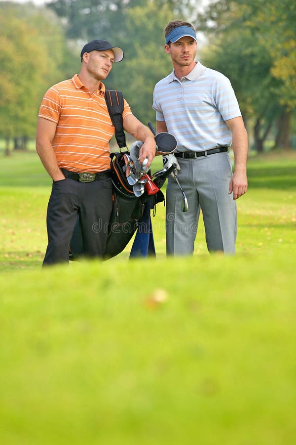 Young Men Standing on Golf Course Carrying Bags Stock Photo - Image of ...