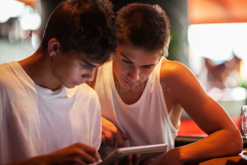 Young Men Using Tablet Computer in Cafe Stock Image - Image of wireless ...