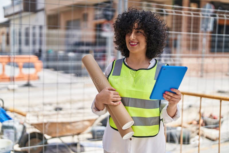 Young Middle East Woman Architect Holding Blueprints Using Touchpad at ...