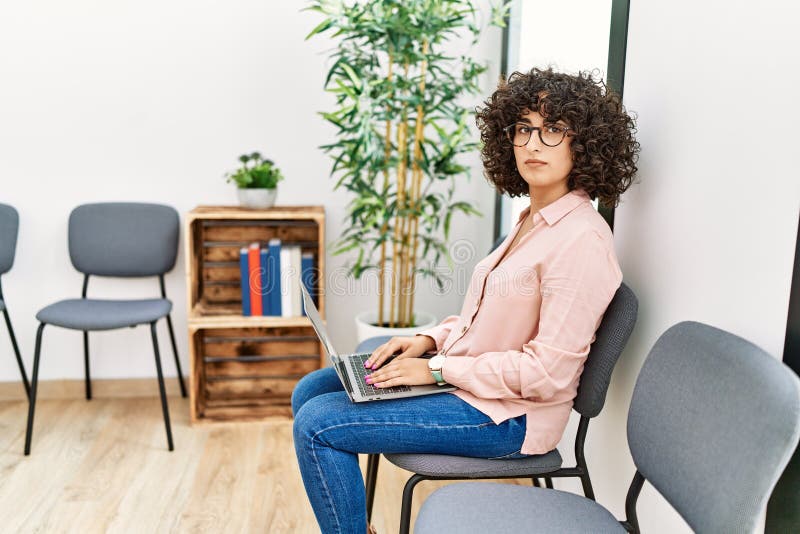 Young Middle Eastern Woman Sitting at Waiting Room Working with Laptop ...