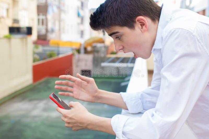 Young Man with a Mobile Phone Standing at the Wall Stock Image - Image ...