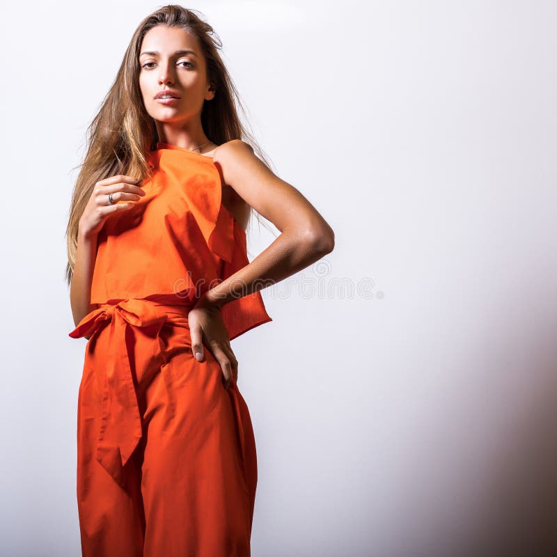 Young Model Woman in Orange Dress Pose in Studio. Stock Photo - Image ...