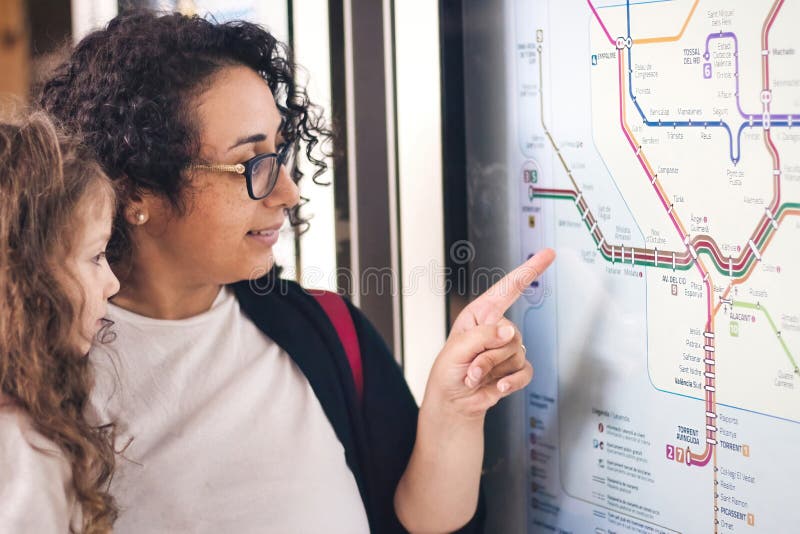 A Young Mother and Daughter Looking and Pointing at a City Metro ...