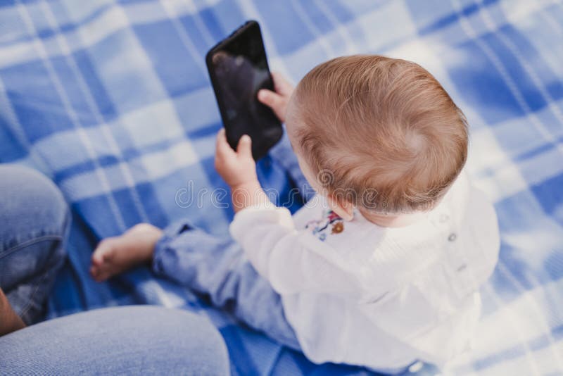 Young Mother and Happy Baby Using Mobile Phone Outdoors. Technology ...