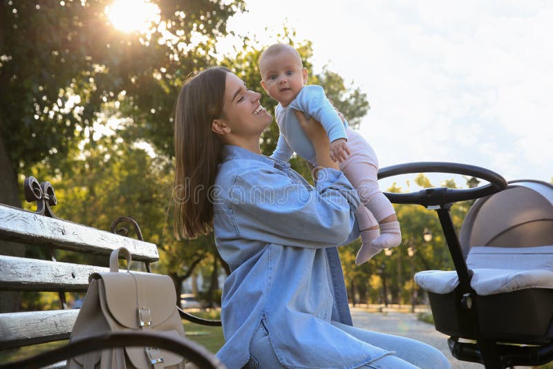Young Mother with Her Baby on Bench in Park Stock Image - Image of ...