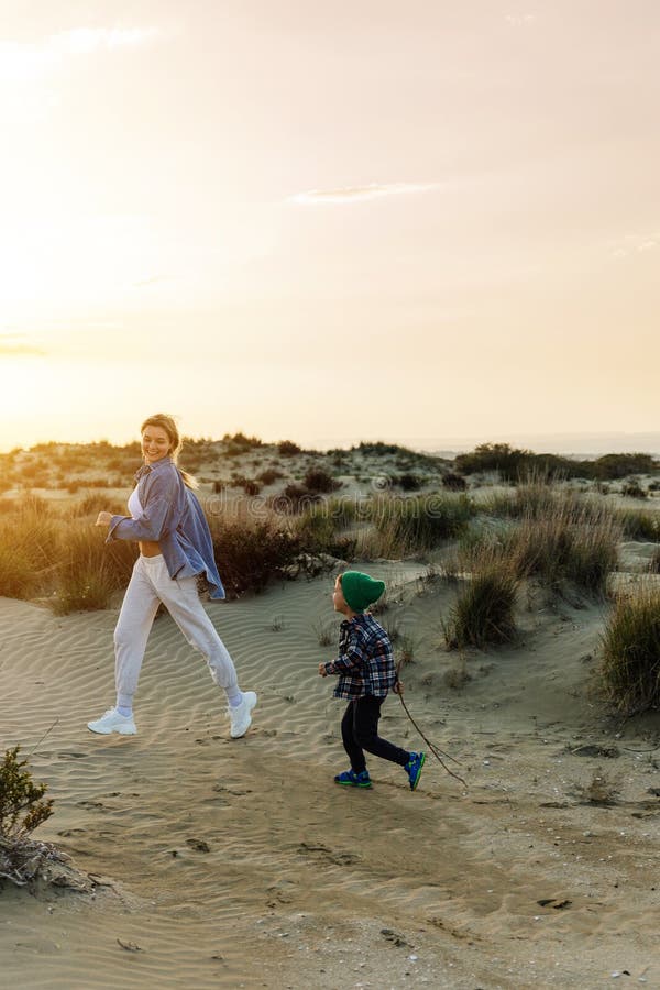 Young Mother and Her Toddler Son Playing Tag on the Beach at Sunset ...