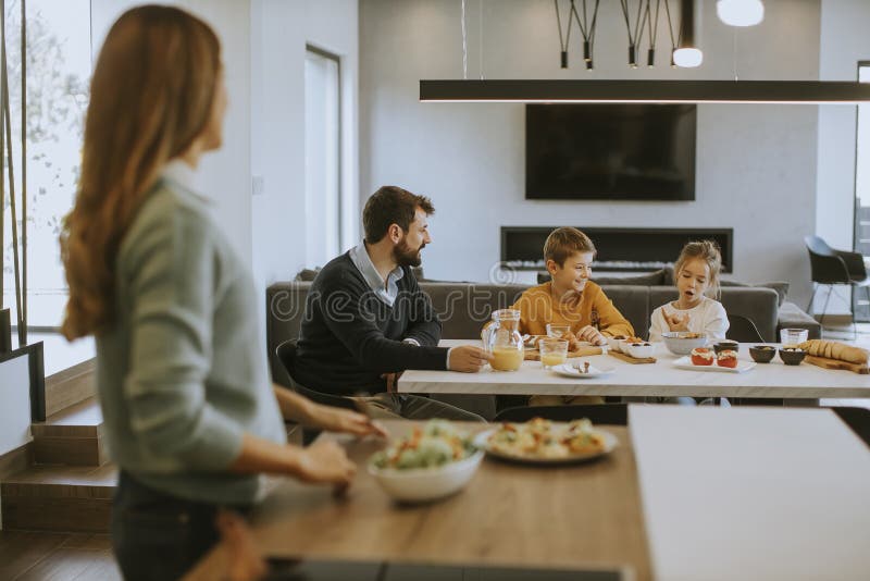 Young Mother Preparing Breakfast for Her Family in the Kitchen Stock ...