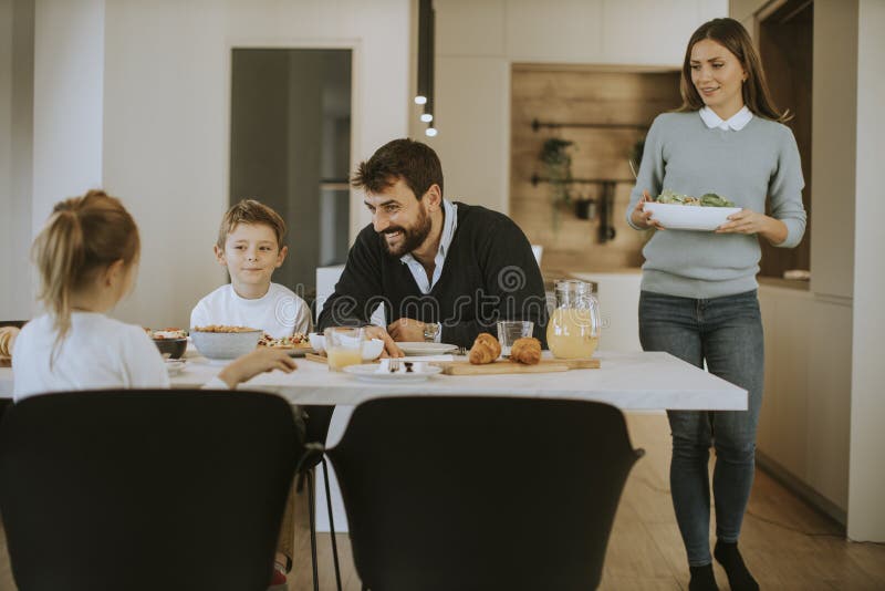 Young Mother Preparing Breakfast for Her Family in the Kitchen Stock ...