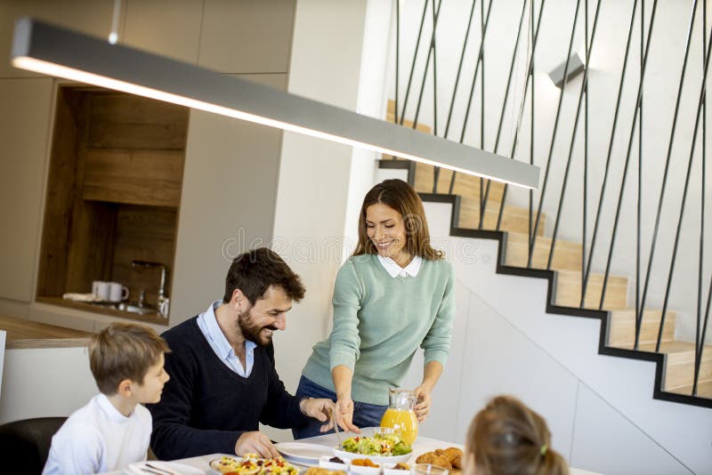 Young Mother Preparing Breakfast for Her Family in the Kitchen Stock ...