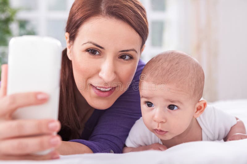 Young Mother with Son Looking To the Mobile Phone Stock Image - Image ...