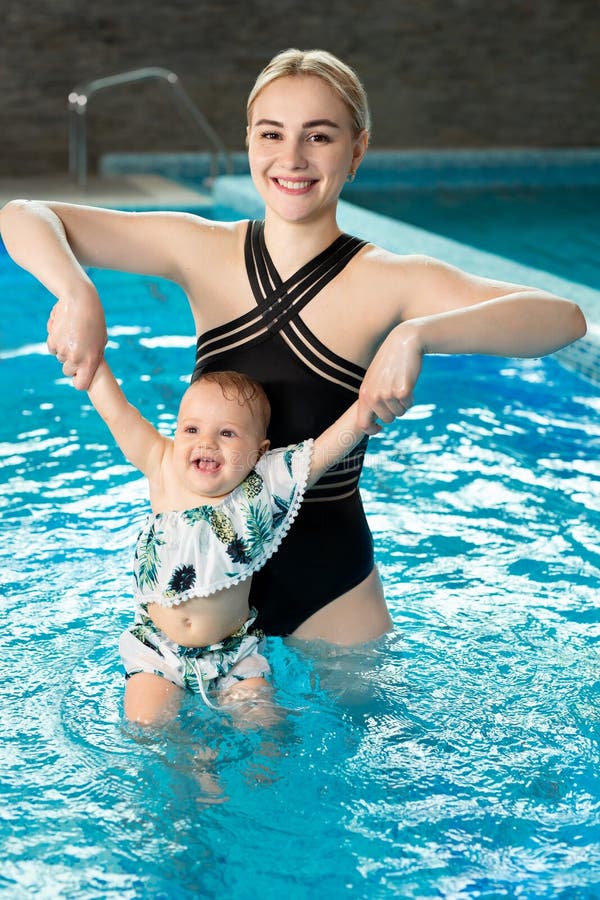 Young Mother, Swimming Instructor and Happy Little Girl in the Pool ... Young Mother, Swimming Instructor and Happy Little Girl in the Pool ...