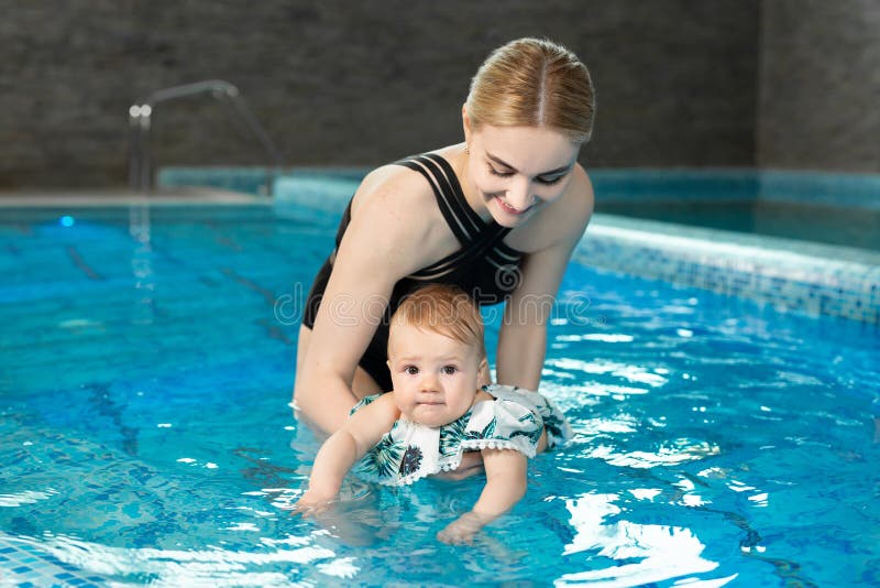 Young Mother, Swimming Instructor and Happy Little Girl in the Pool ... Young Mother, Swimming Instructor and Happy Little Girl in the Pool ...