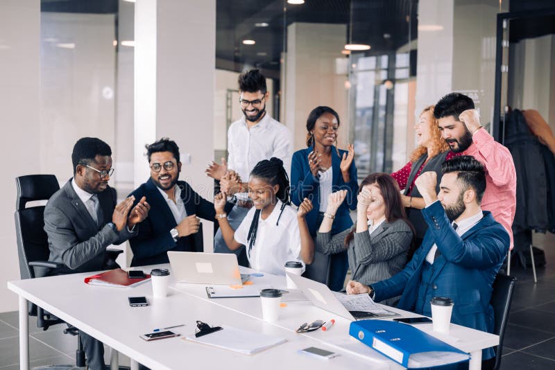 Young Multi-ethnic Work Team Exchanges Ideas Gathering Around Laptop ...