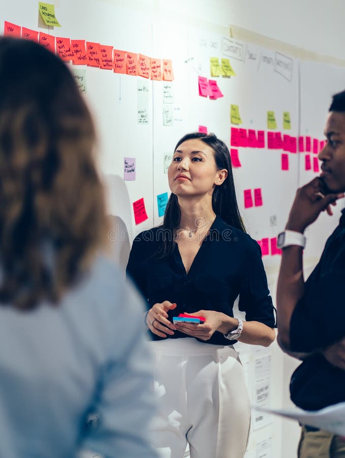 Young Multiethnic Colleagues in Formal Wear Briefing with Sticky Notes ...