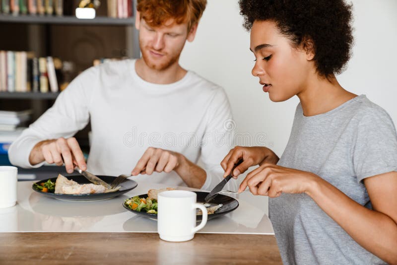 Young Multinational Couple Smiling while Having Breakfast at Home Stock ...