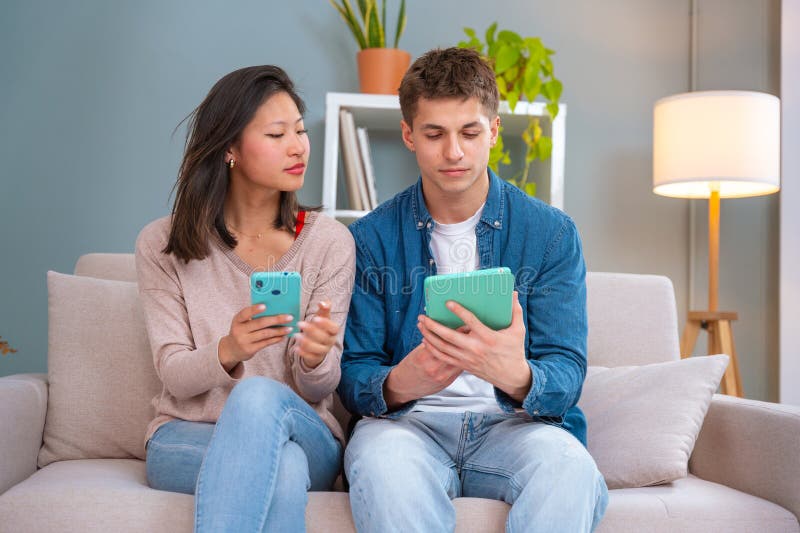 Happy Multiethnic Man and Woman Have Fun Browsing the Internet on a ...