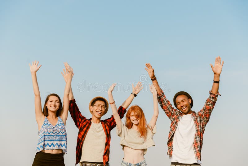 Young Multiracial Friends Laughing while Posing with Hands Up Stock ...