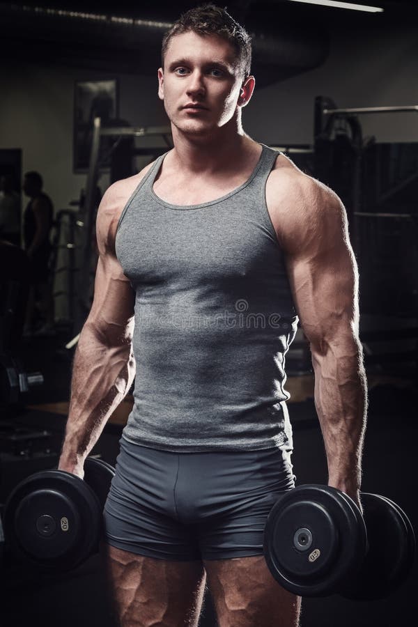 Muscular Man with Dumbbells in the Gym Stock Photo - Image of muscular ...