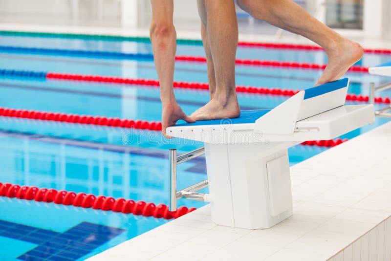 Young Muscular Swimmer in Low Position on Starting Block in a Swimming ...