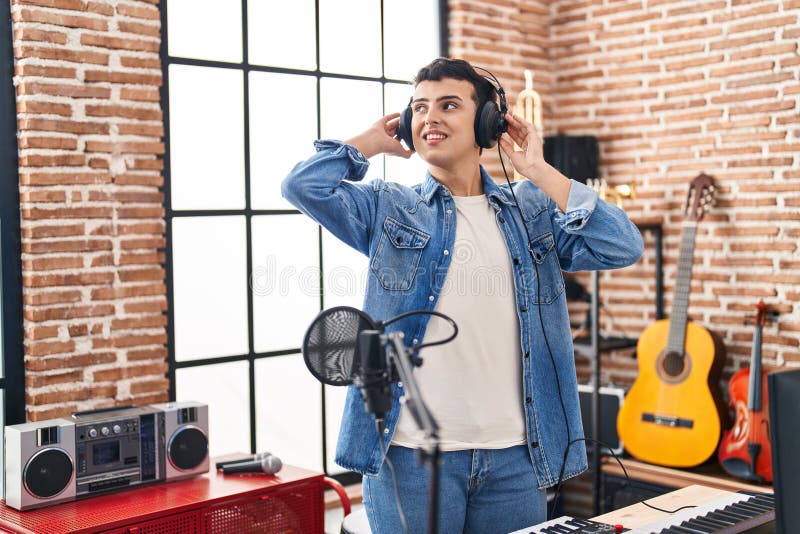 Young Non Binary Man Artist Listening To Music at Music Studio Stock ...