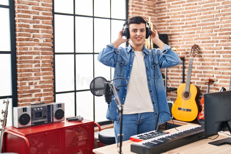 Young Non Binary Man Artist Listening To Music at Music Studio Stock ...