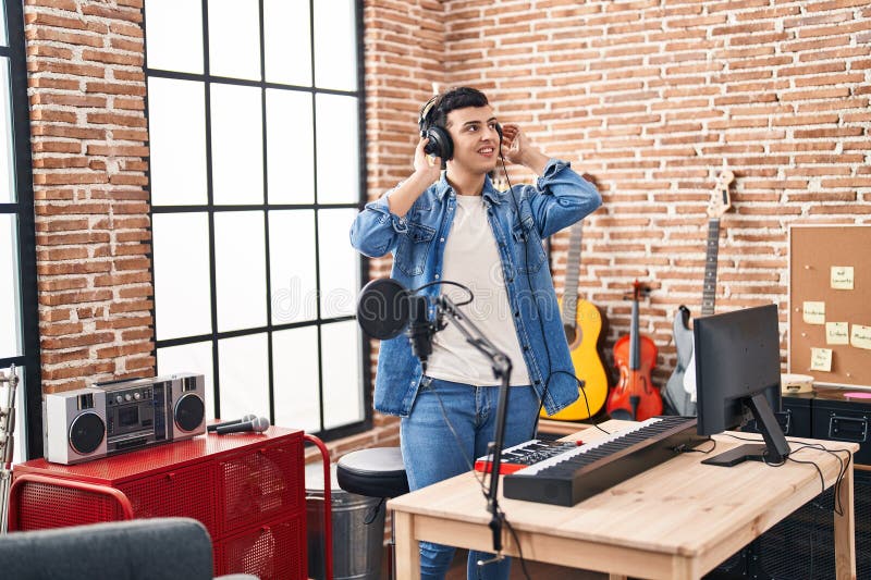 Young Non Binary Man Artist Listening To Music at Music Studio Stock ...