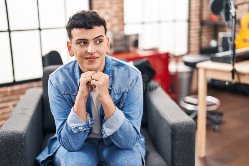 Young Non Binary Man Musician Smiling Confident Sitting on Chair at ...