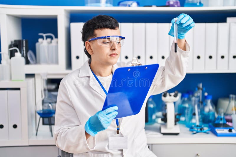Young Non Binary Man Scientist Reading Report Holding Blood Test Tube ...