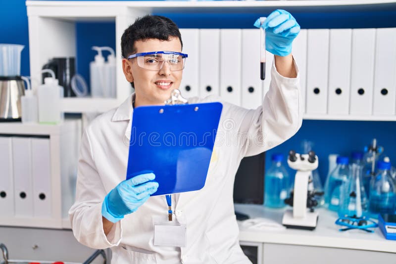 Young Non Binary Man Scientist Reading Report Holding Blood Test Tube ...
