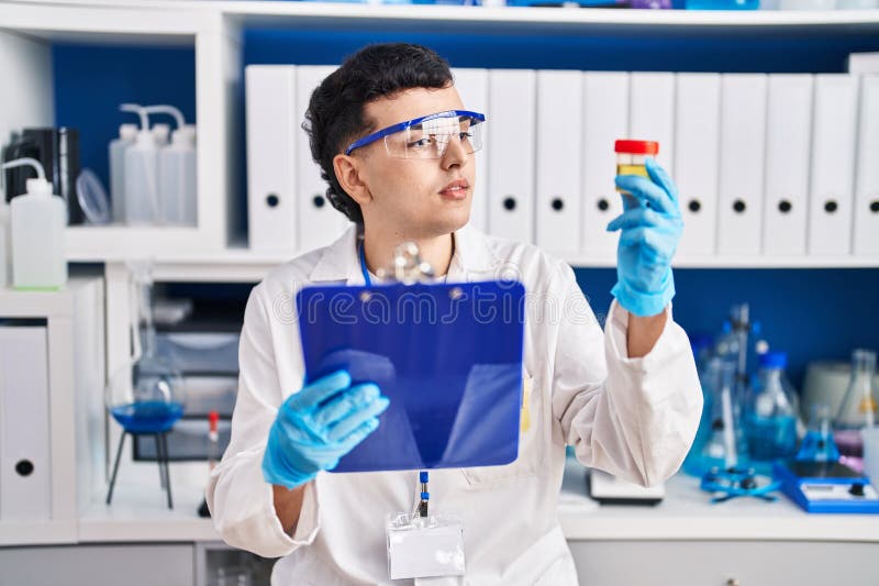 Young Non Binary Man Scientist Reading Report Holding Urine Test Tube ...