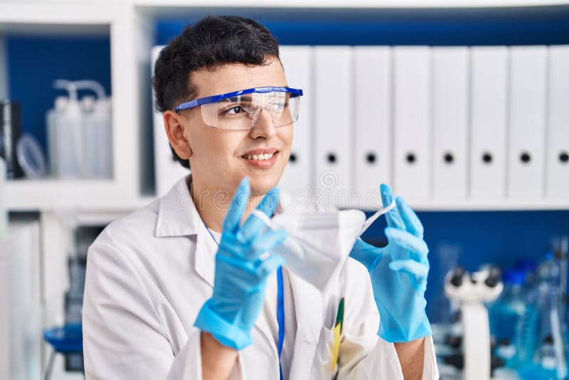 Young Non Binary Man Scientist Smiling Confident Holding Medical Mask ...